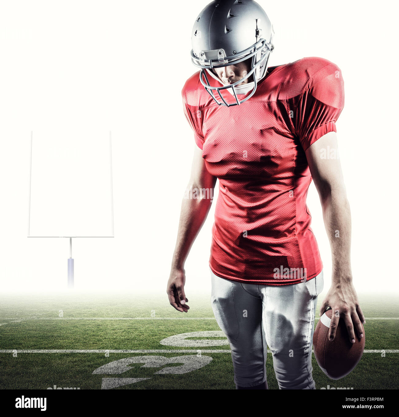 Composite image of american football player looking down while standing ...