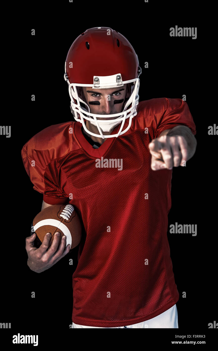 Composite image of portrait of rugby player pointing while holding ball ...