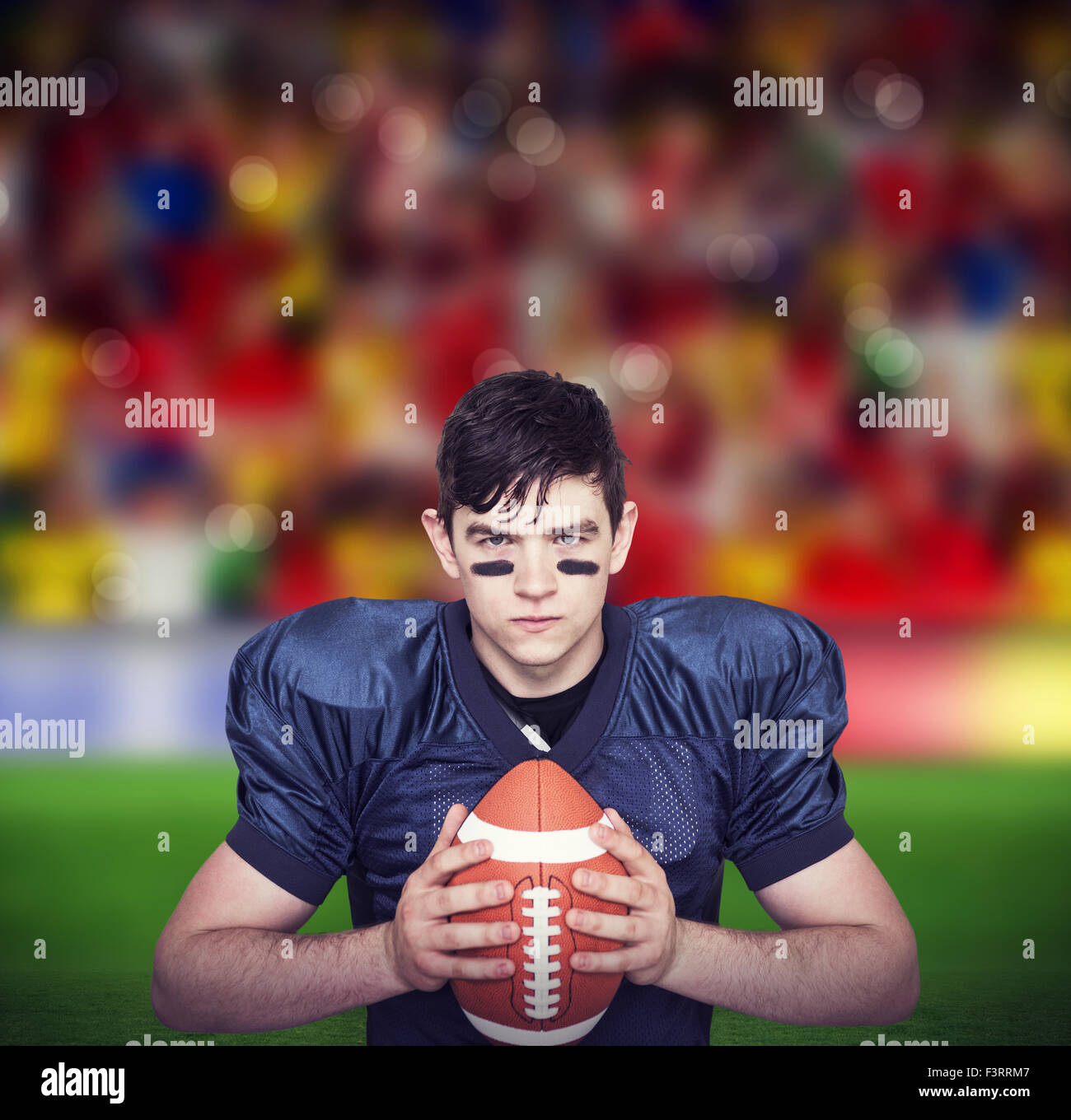 Composite image of determined american football player holding a ball ...