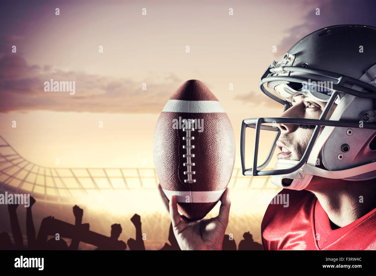 Composite image of sportsman looking up while holding american football ...