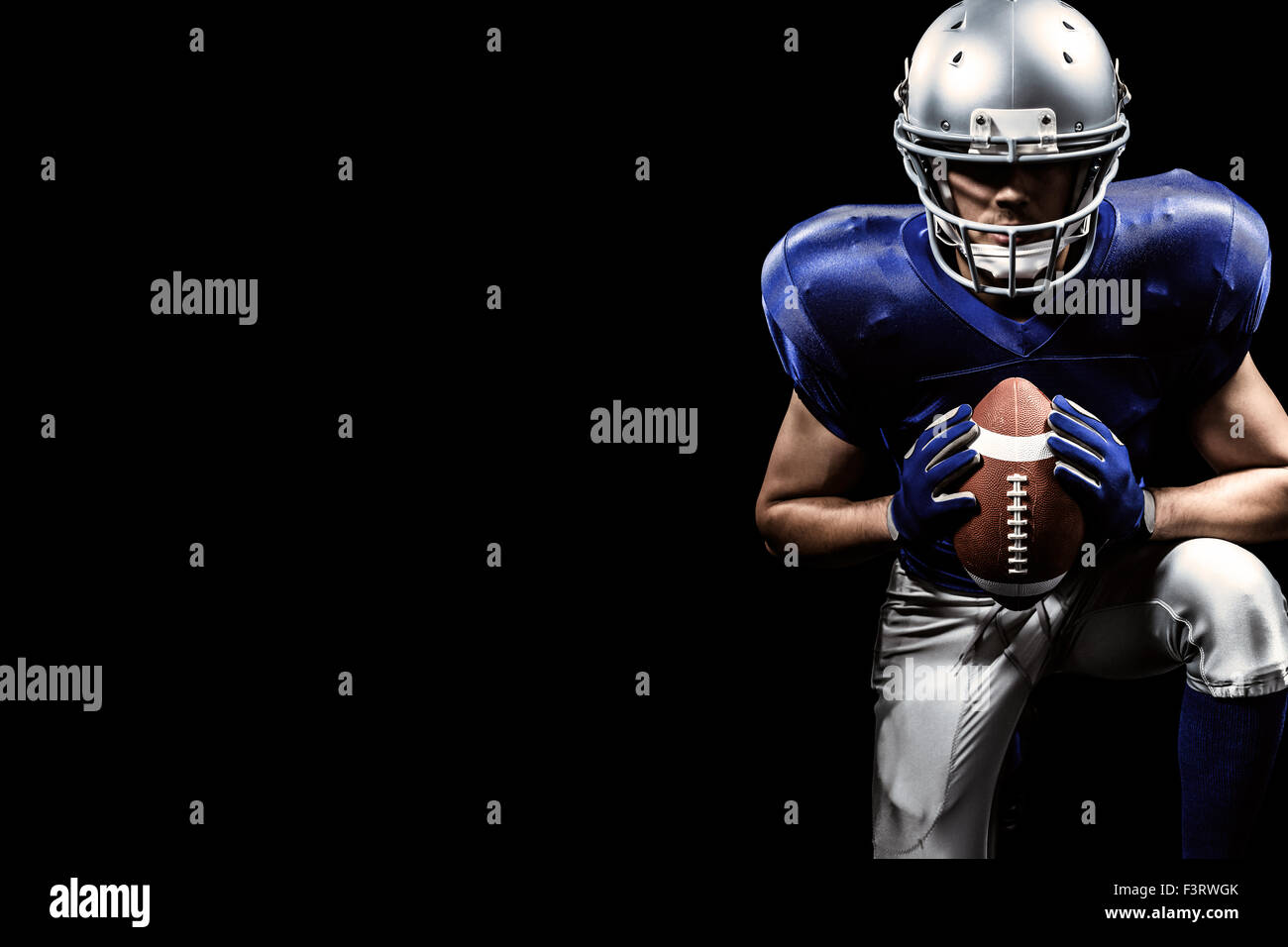 Composite image of determined american football player holding ball ...