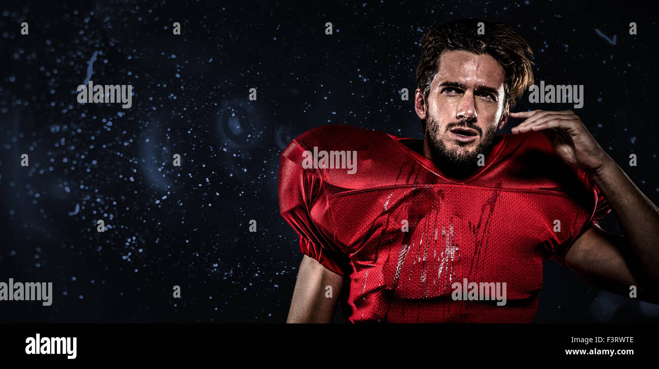 Composite image of wet american football player in red jersey looking ...