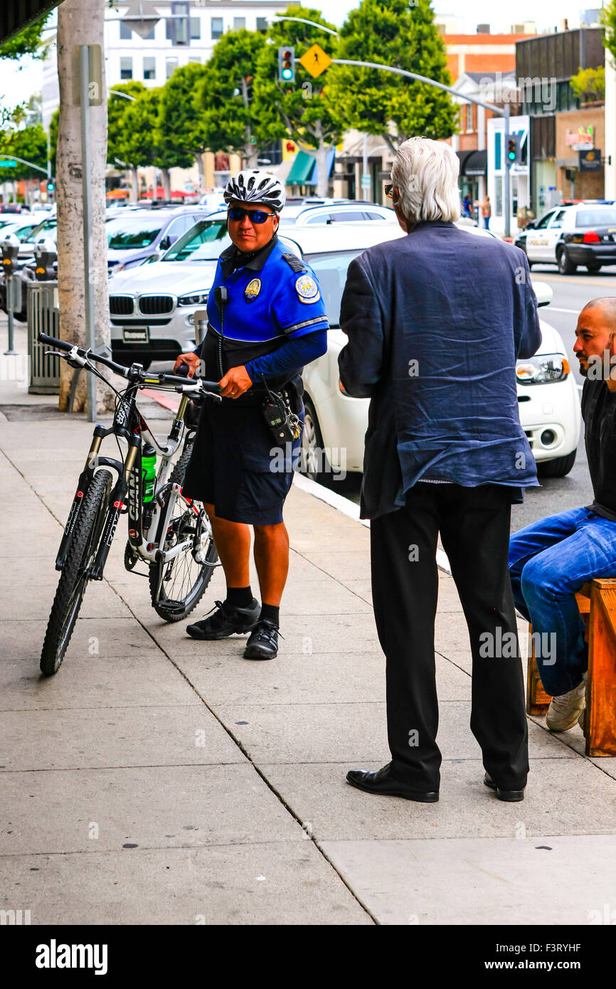 A Beverly Hills bicycle cop stops to talk to local people Stock Photo ...