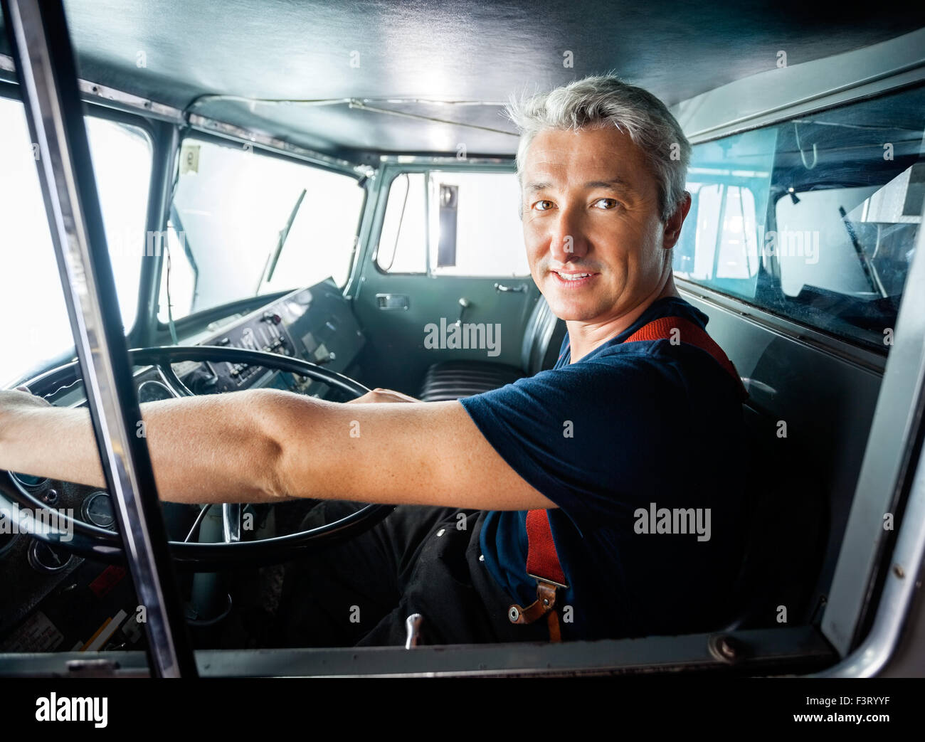 Confident Fireman Driving Firetruck Stock Photo - Alamy