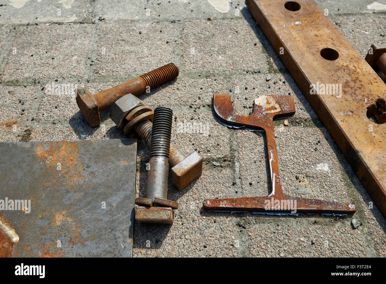Three big bolts and a key on the ground Stock Photo - Alamy