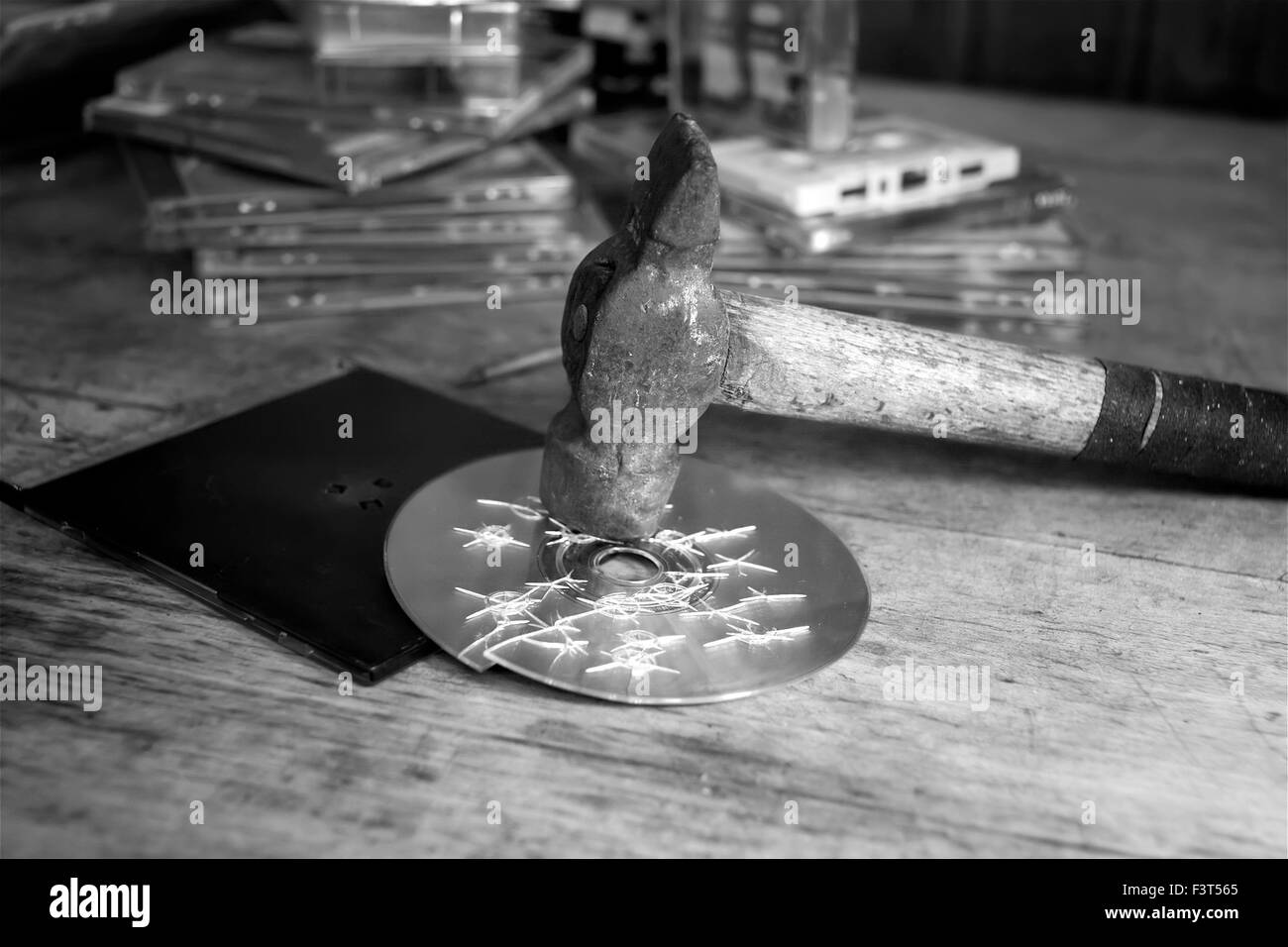 Hammer on a smashed compact disc Stock Photo - Alamy