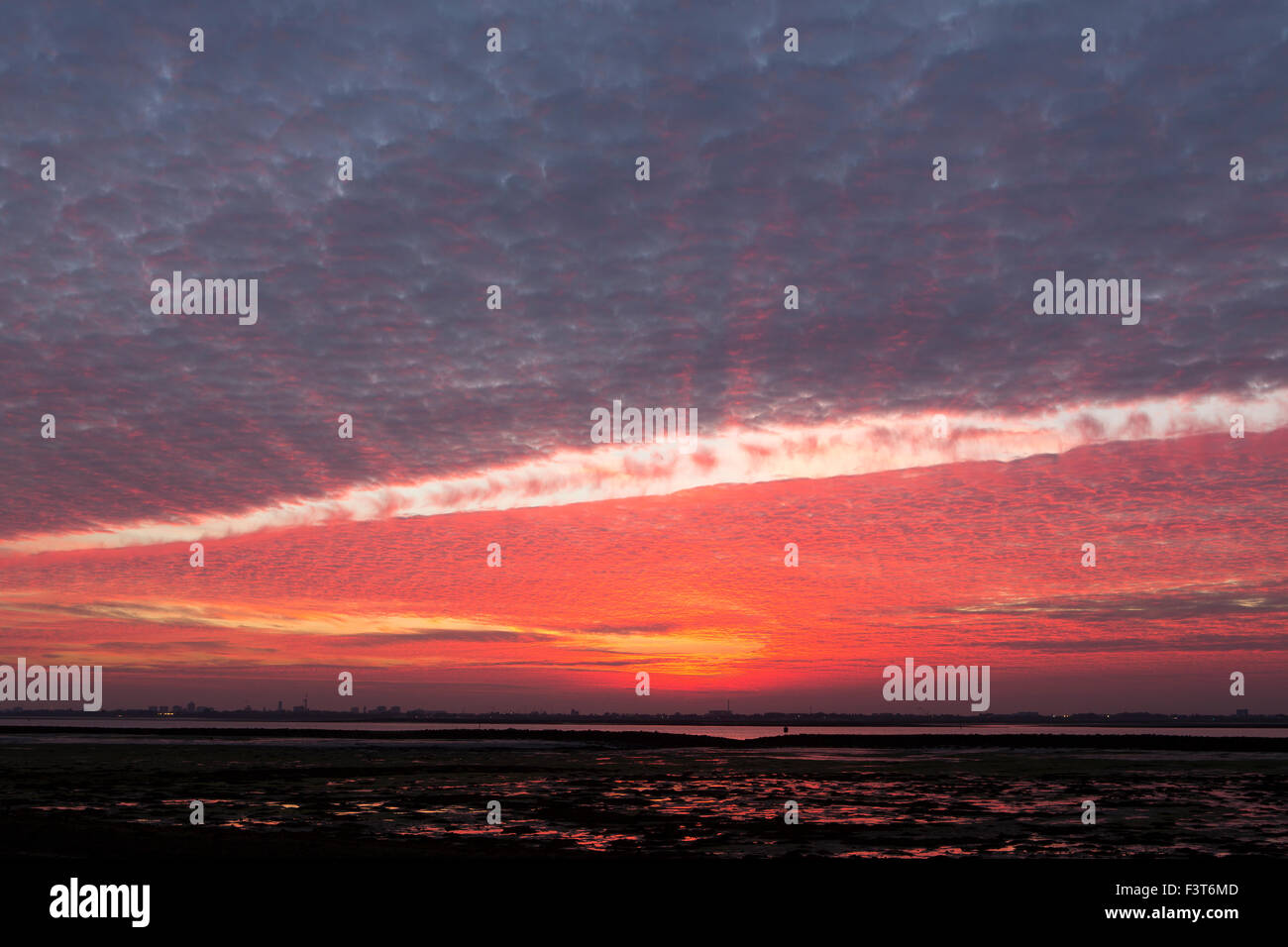 Spectacular sunset with unusual cloud formations. Alien sky with a rip ...