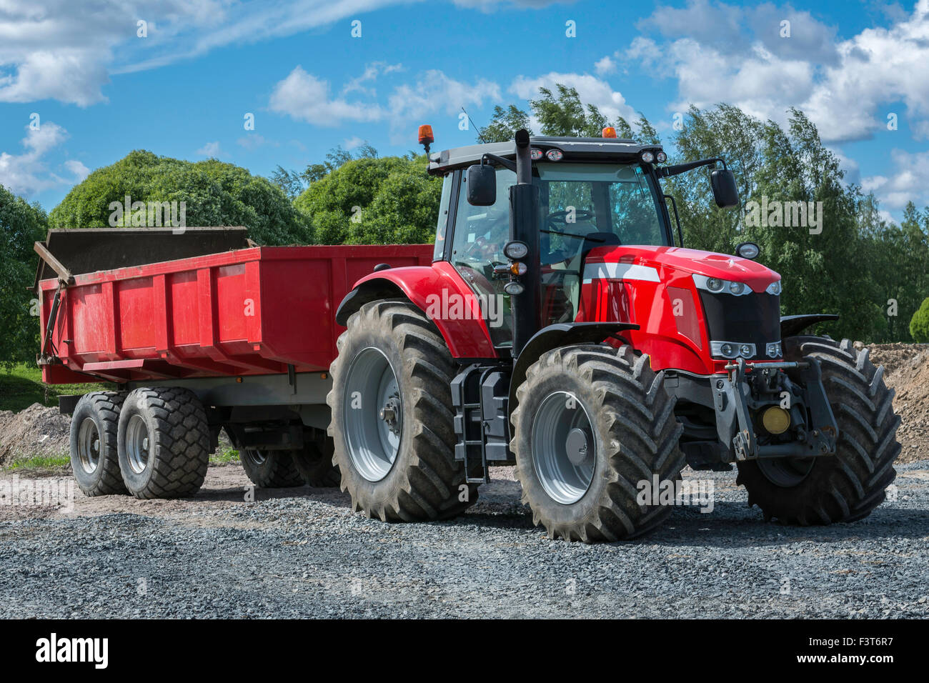Red tractor with a trailer Stock Photo - Alamy