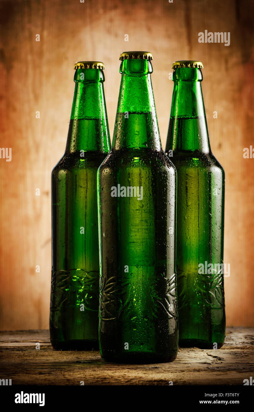Wet beer bottles on rustic wooden table Stock Photo - Alamy