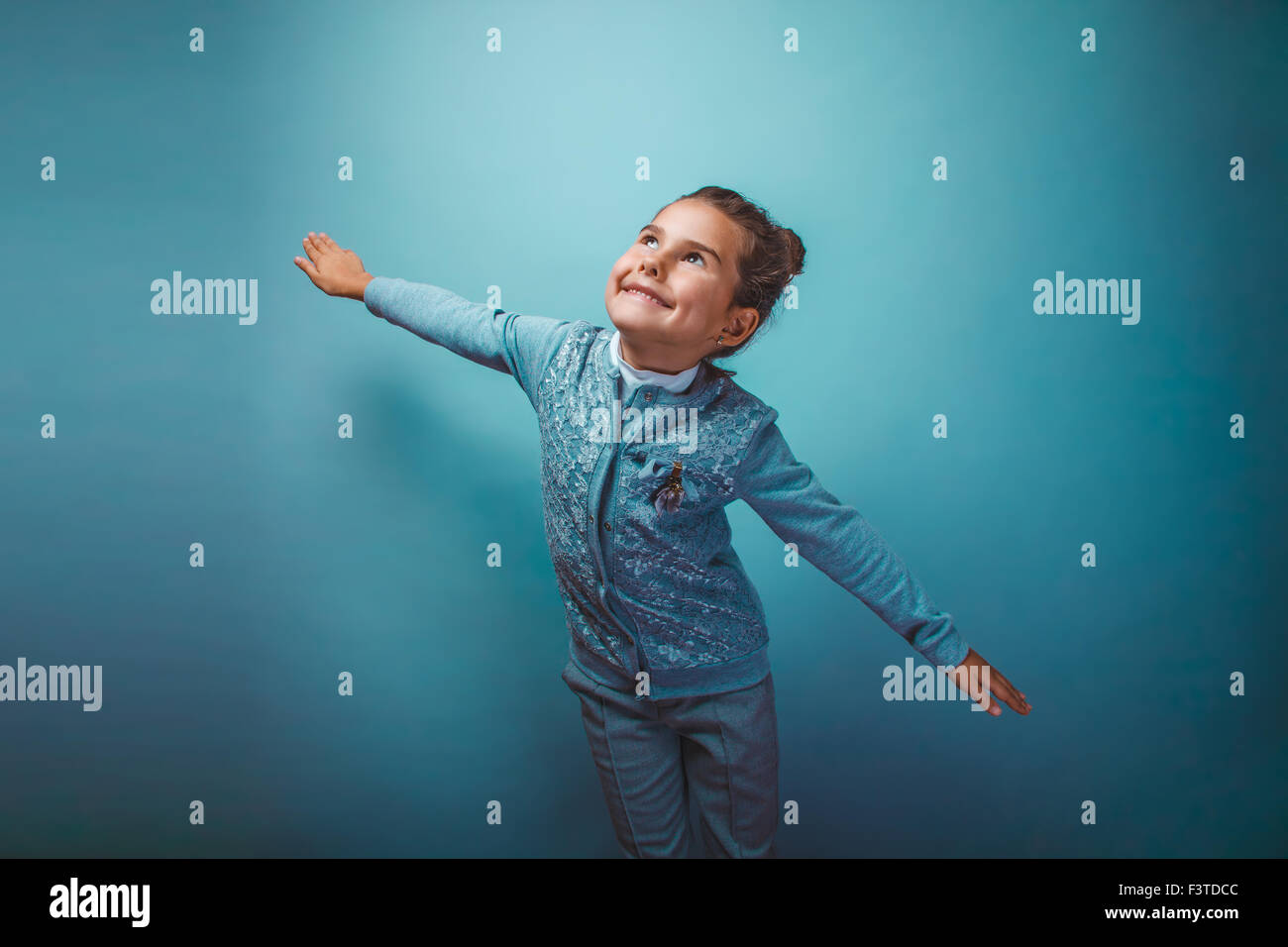 teen girl seven years shows a flying hands on a gray background Stock ...