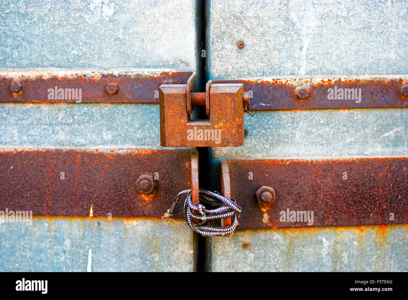 An old rusty lock hanging on the gates, copy space Stock Photo - Alamy