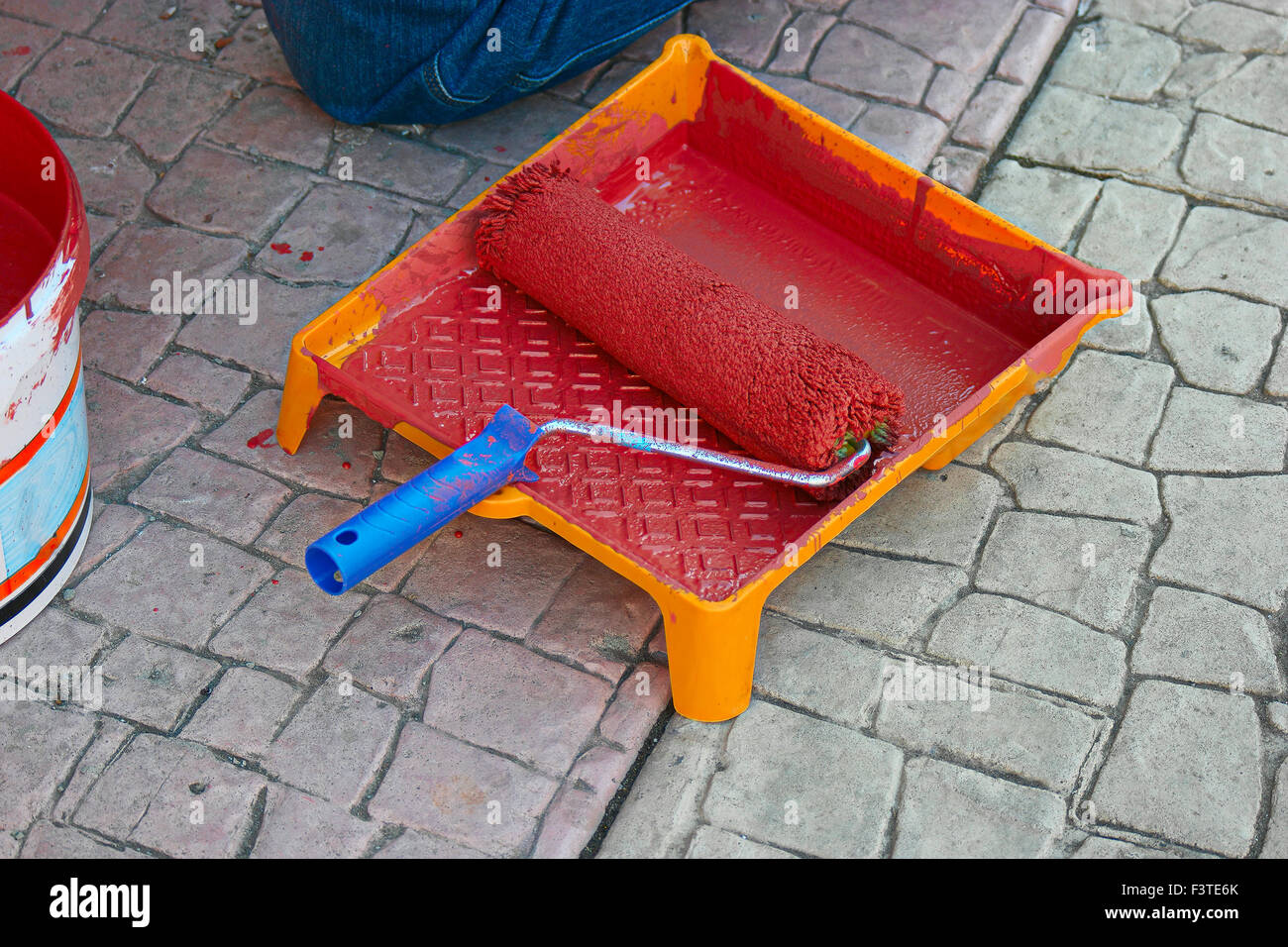 Paint roller (roll) and tub with red color paint Stock Photo - Alamy