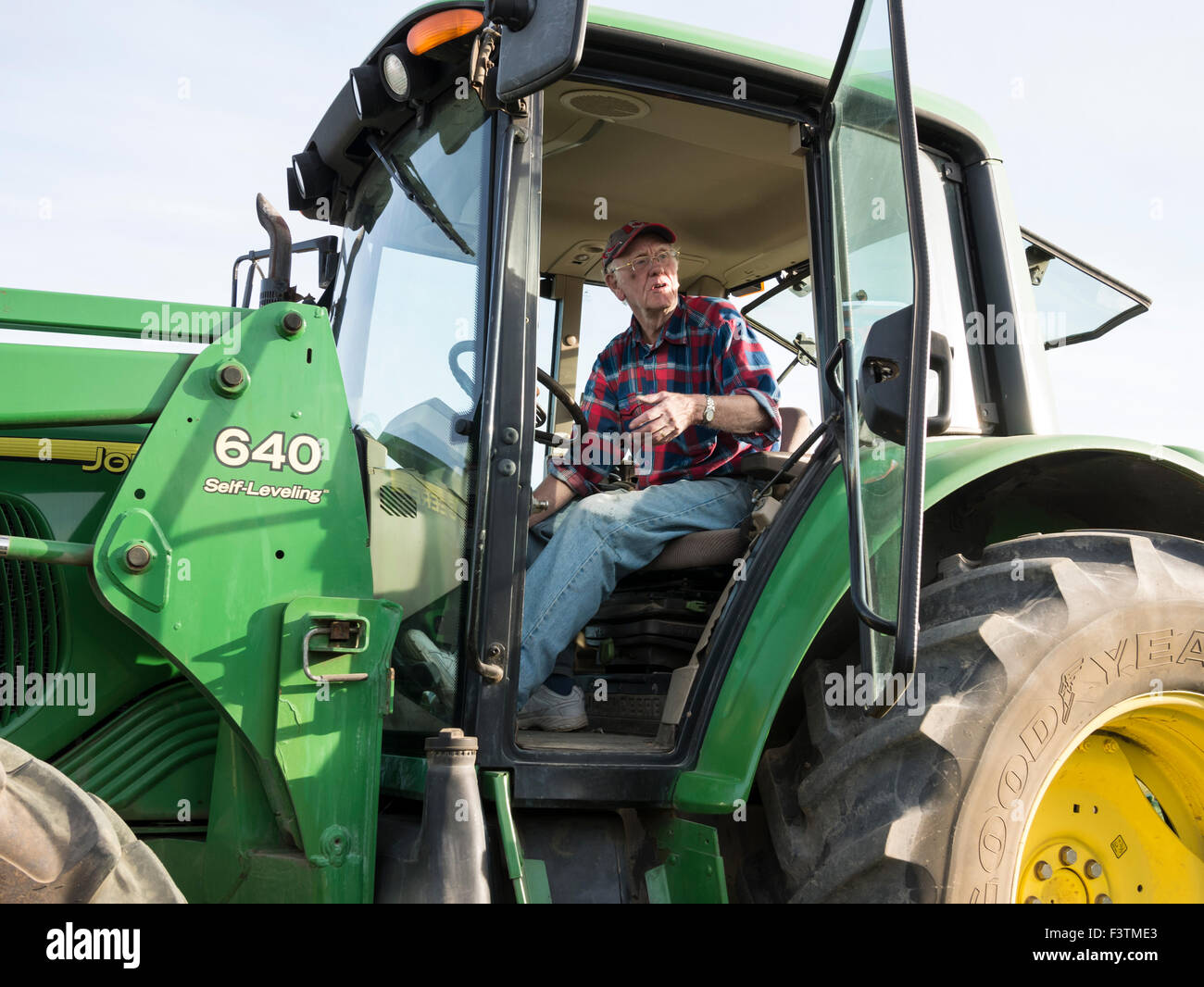 A farmer in a tractor Stock Photo - Alamy