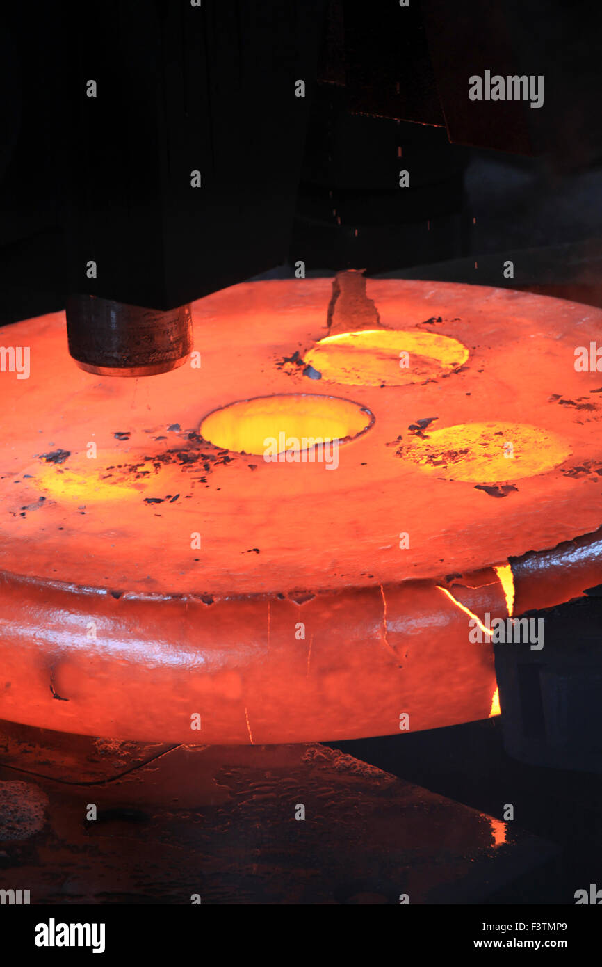 Heated metal pig gets squeezed and drilled at special metal forging ...