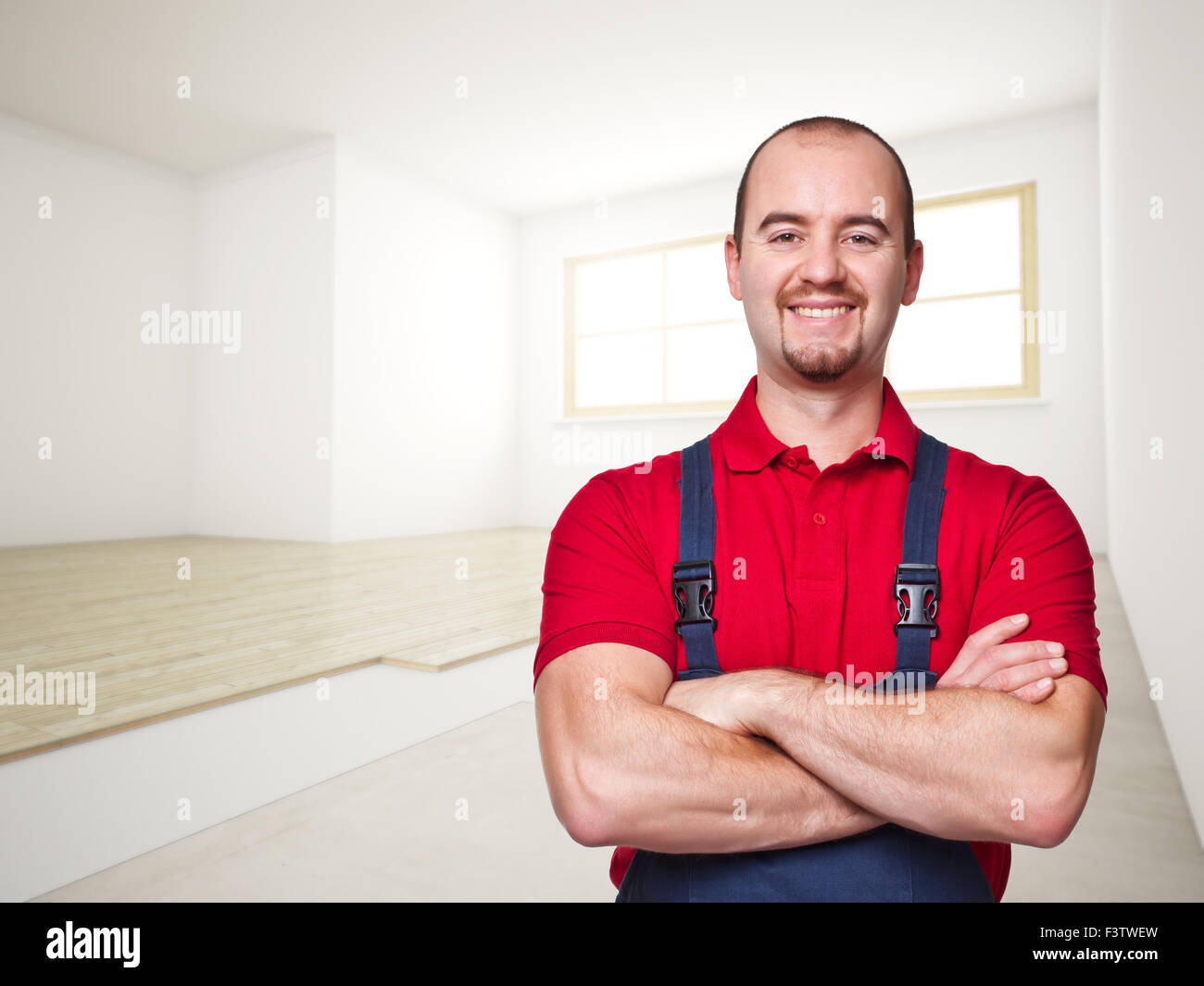 smiling handyman and house interior background Stock Photo - Alamy