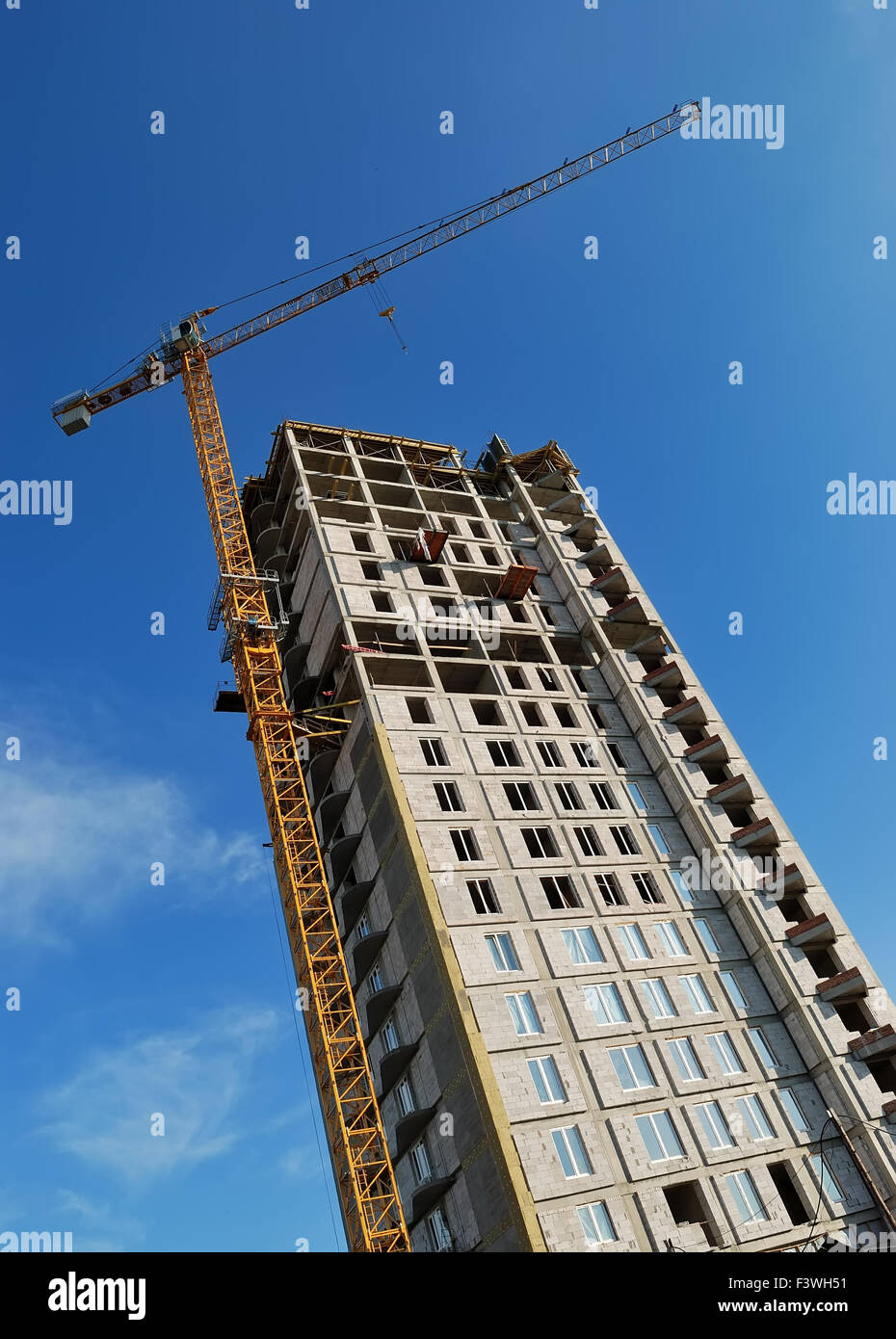 Yellow tower crane at multistory building Stock Photo - Alamy