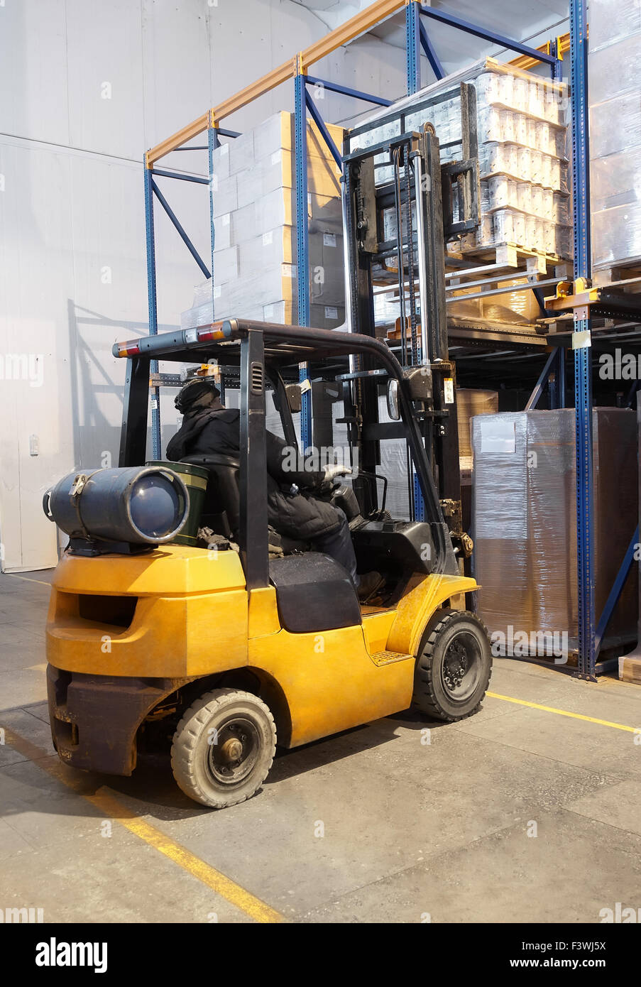 forklift loader stacking in warehouse Stock Photo - Alamy