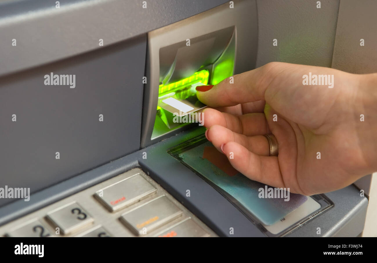 Inserting plastic card visa into ATM Stock Photo - Alamy