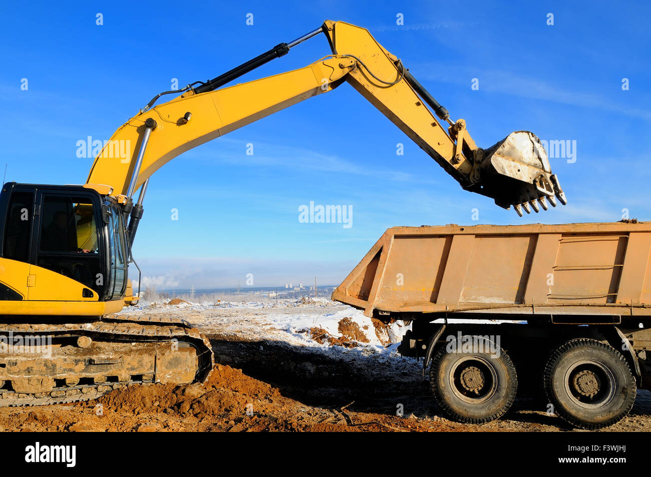 loader excavator and rear-end tipper dumper Stock Photo - Alamy