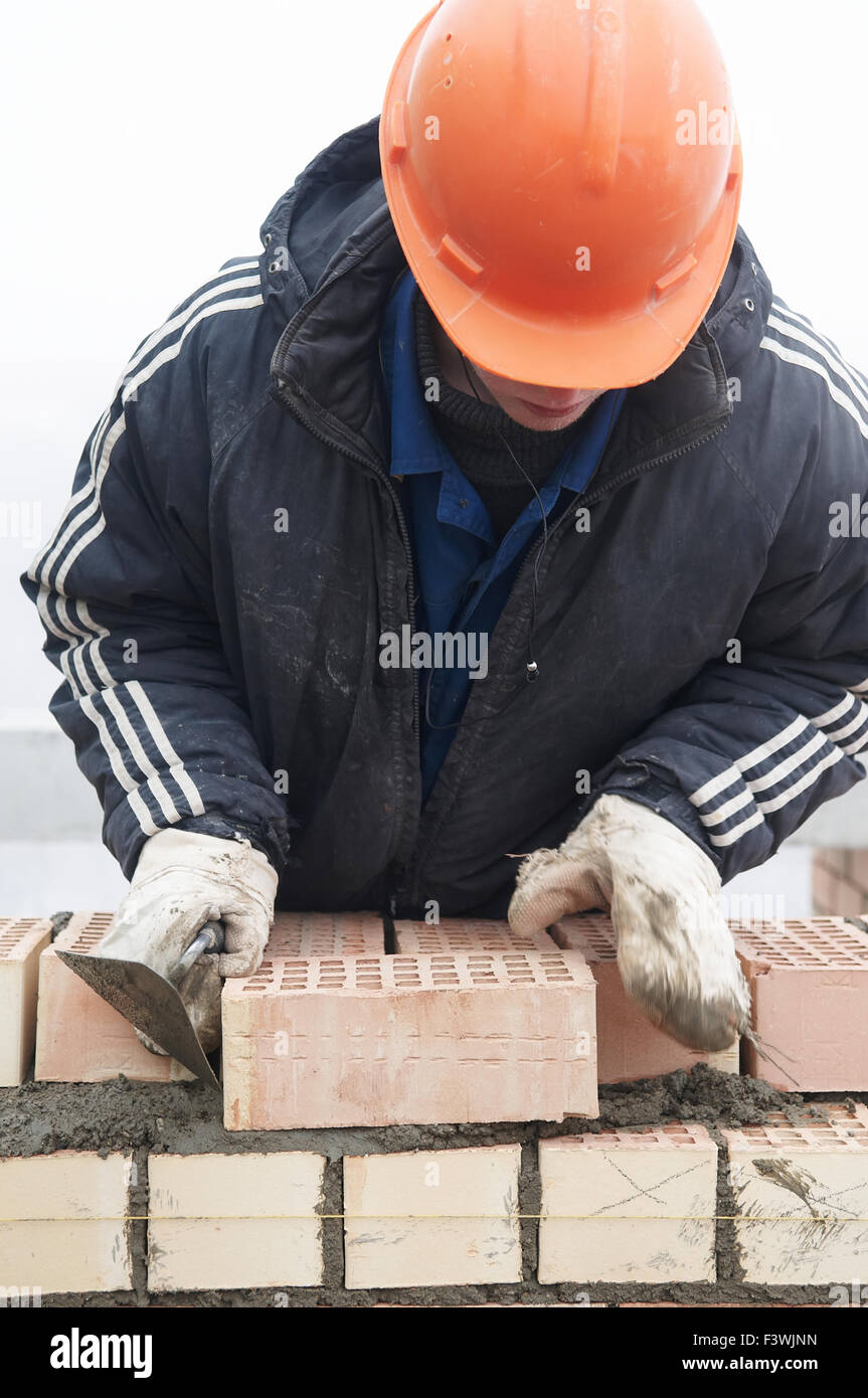 Brick layer worker builder mason Stock Photo - Alamy
