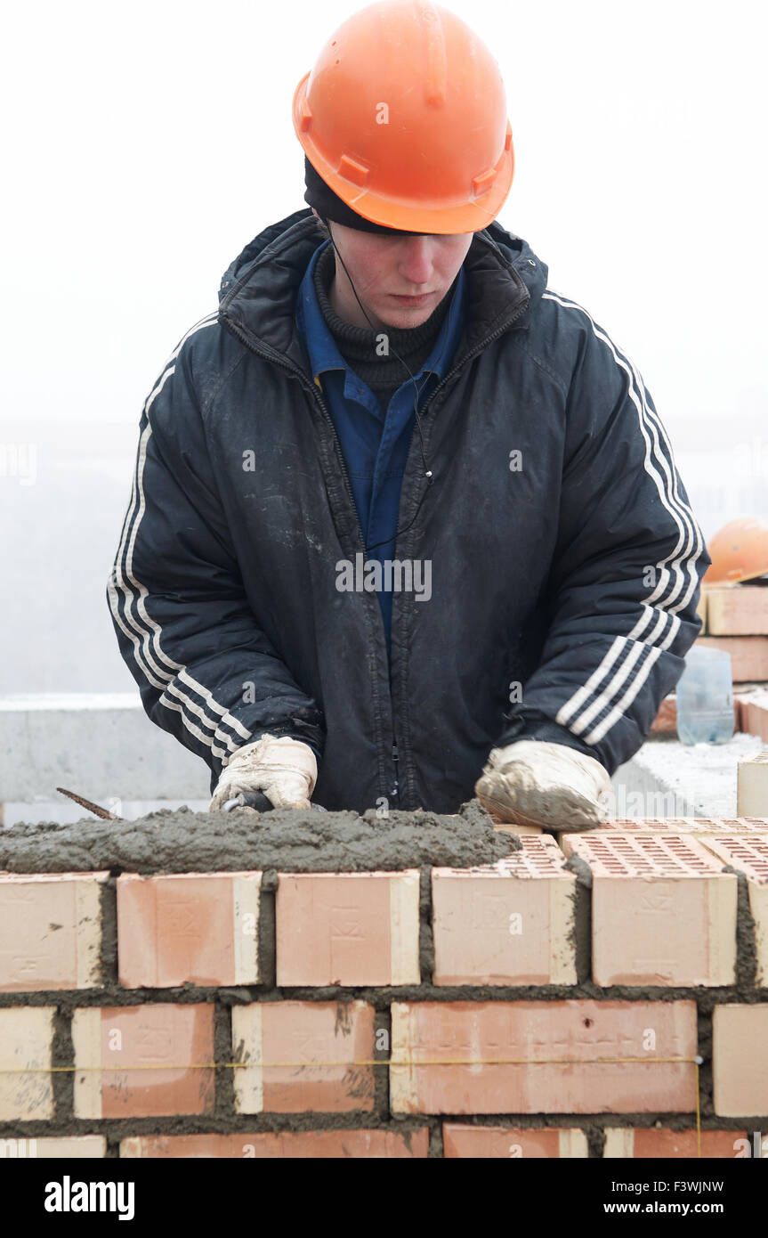 Brick layer worker builder mason Stock Photo - Alamy