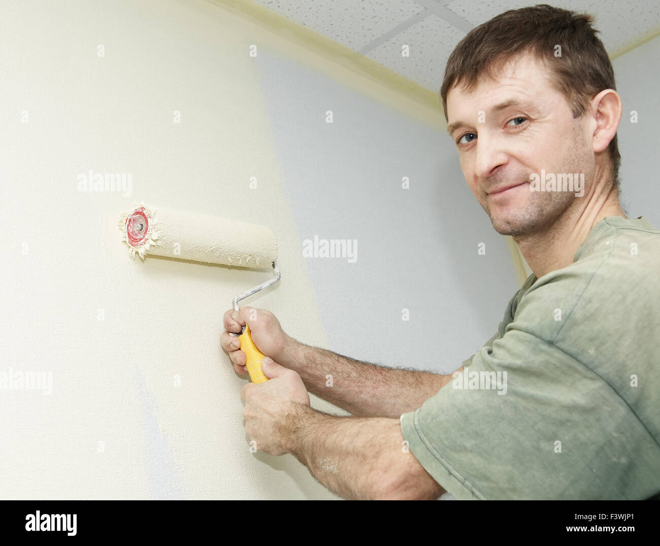 Painter worker with roller at work Stock Photo - Alamy