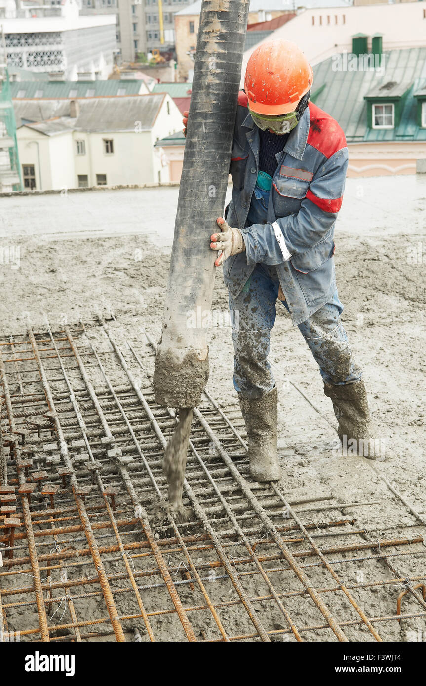 builder worker pouring concrete into form Stock Photo - Alamy