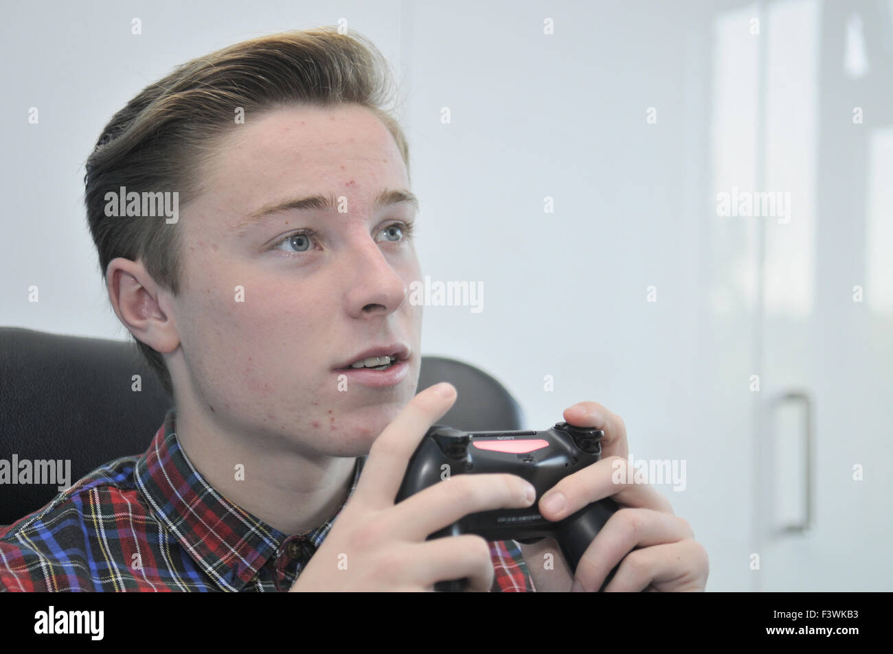 Teenage boy holding a Sony Playstation4 controller Stock Photo - Alamy