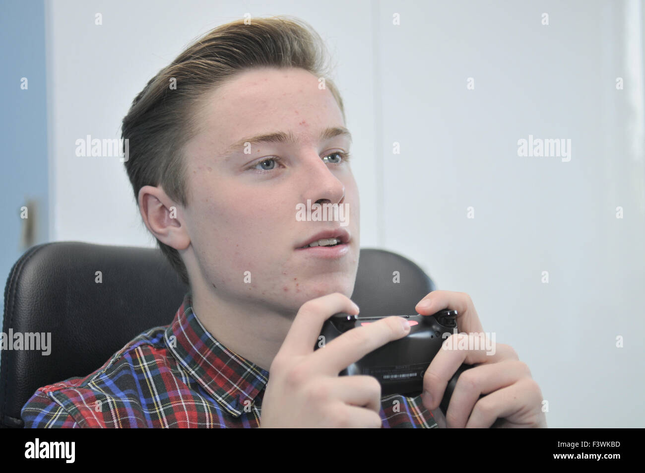 Teenage boy holding a Sony Playstation4 controller Stock Photo - Alamy