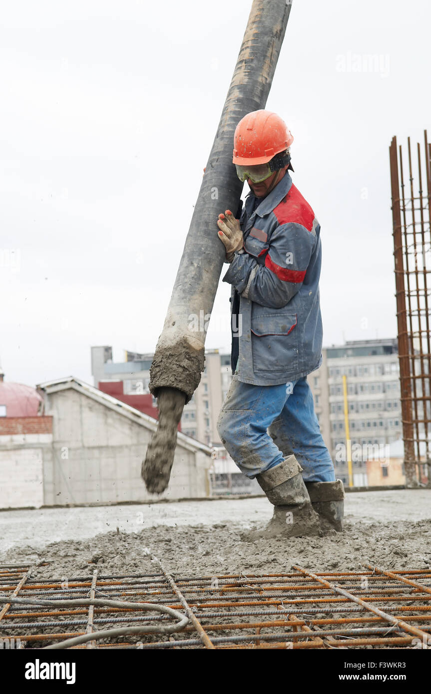 builder worker pouring concrete into form Stock Photo - Alamy