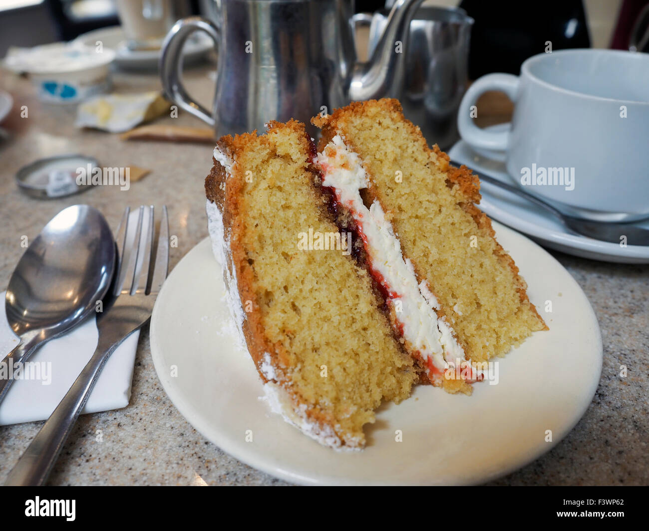 piece/slice of Victoria sponge cake served on plate with cutlery tea ...