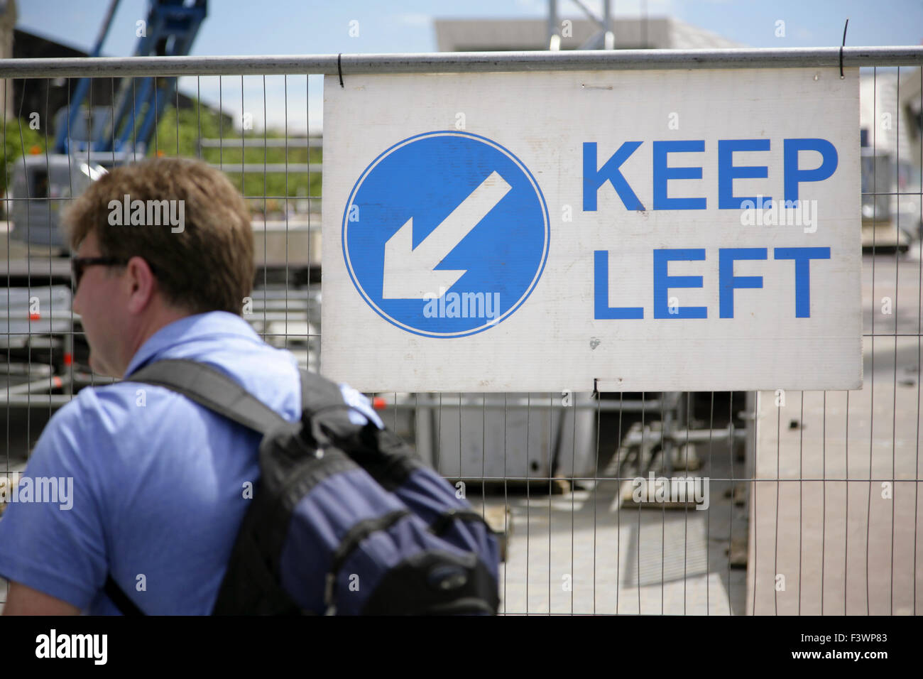 Man walking to the left side of "Keep Left" sign Stock Photo - Alamy