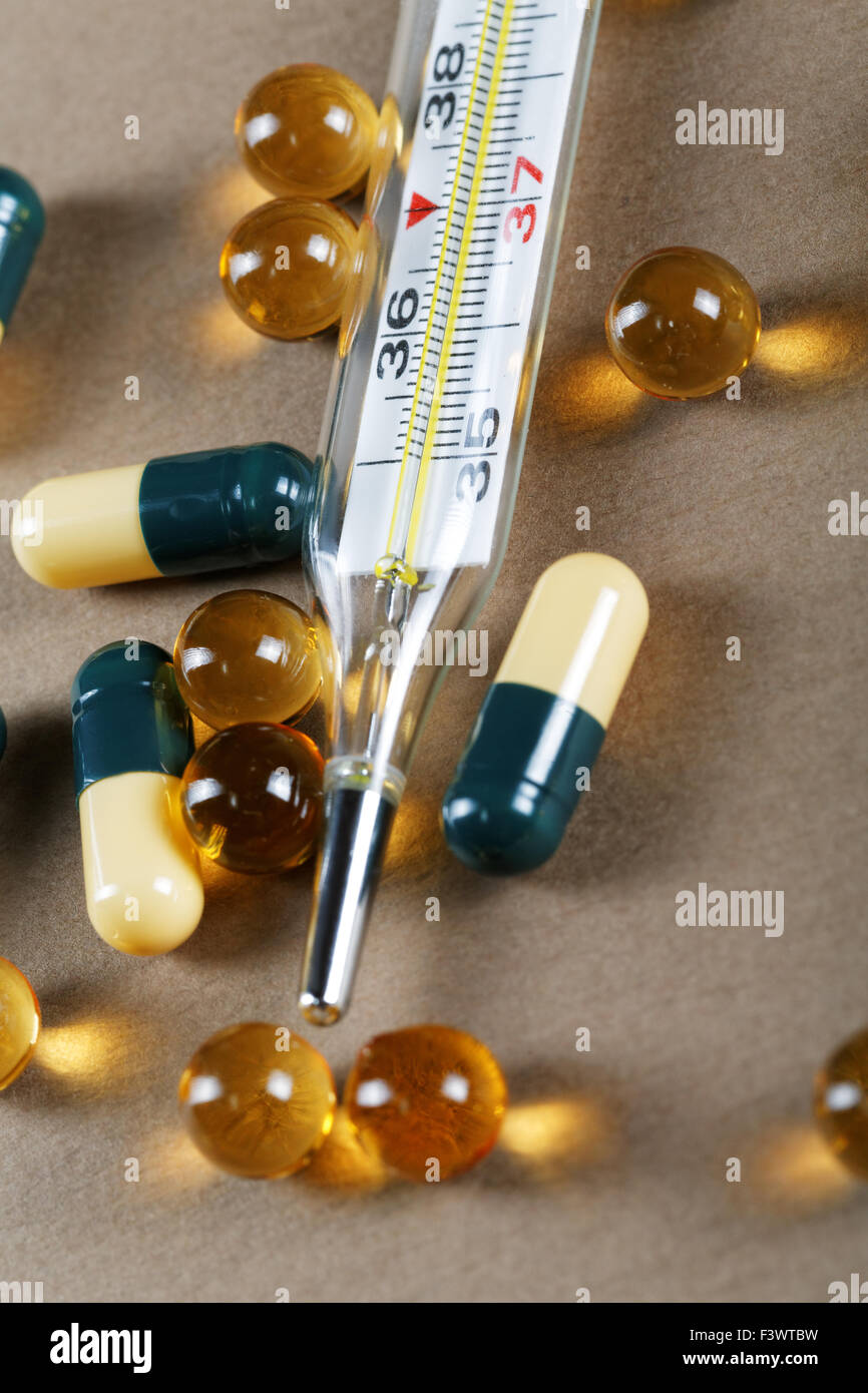 The thermometer and capsules with medicines close up Stock Photo - Alamy