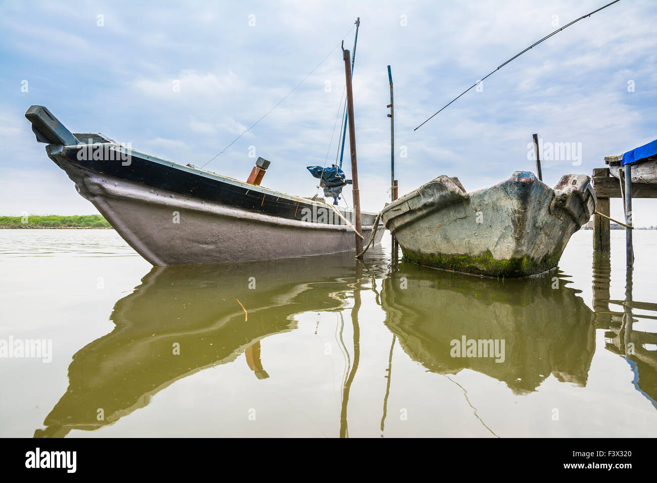Old fishing boats moored in a swamp during a cloudy day Stock Photo - Alamy