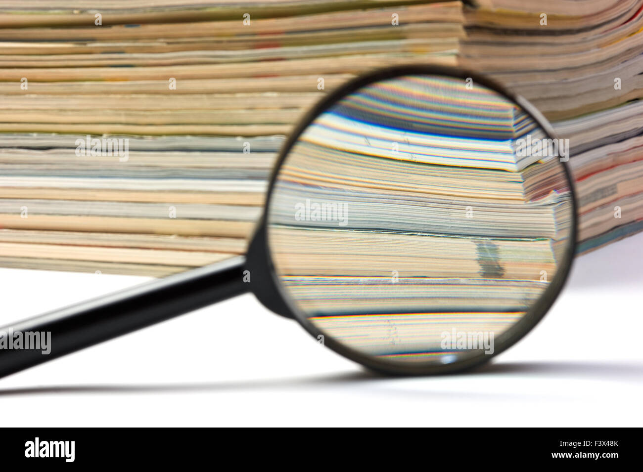 magnifier and stack of magazines Stock Photo - Alamy
