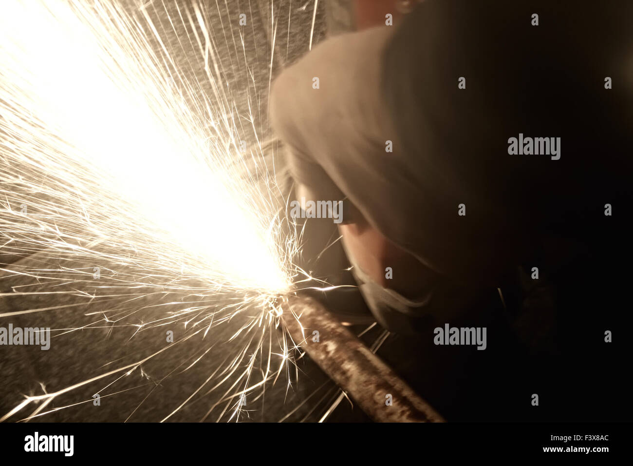 Sparks from a worker grinding steel Stock Photo - Alamy