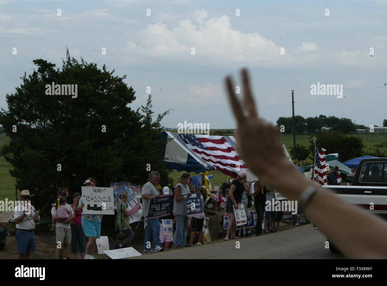 an anti-war protest flashes a peace sign at counter protesters who ...
