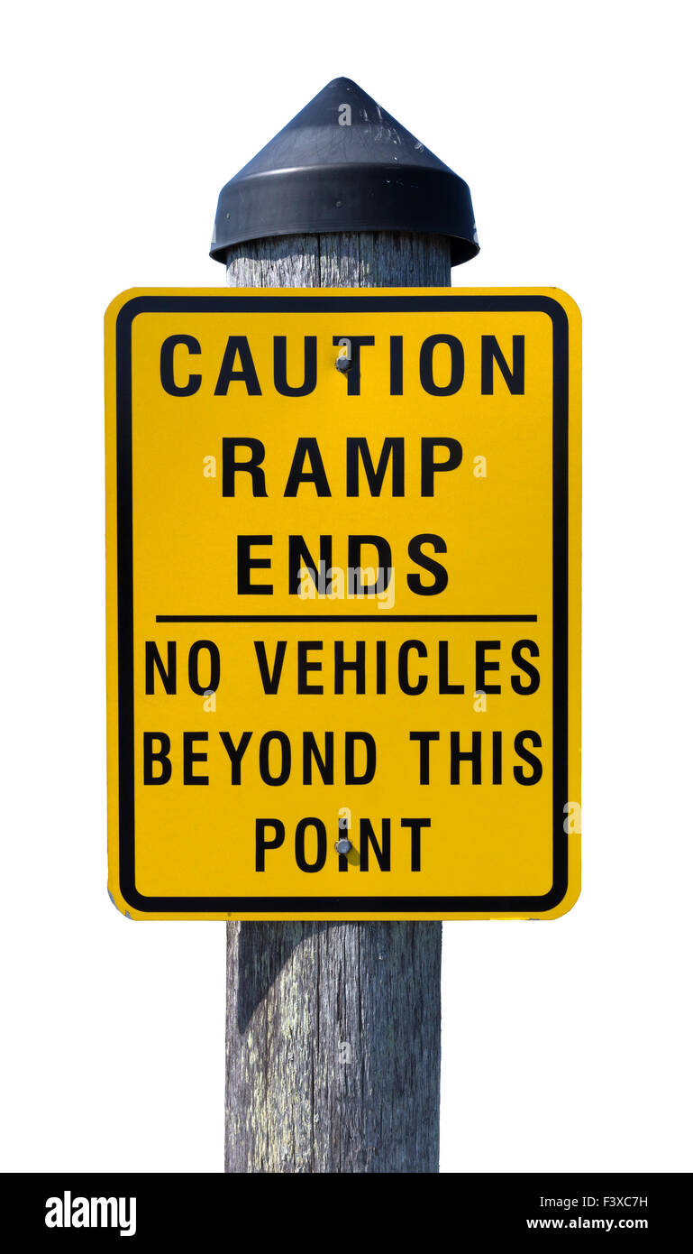 A bright Caution Ramp Ends sign on a wood post against a white ...