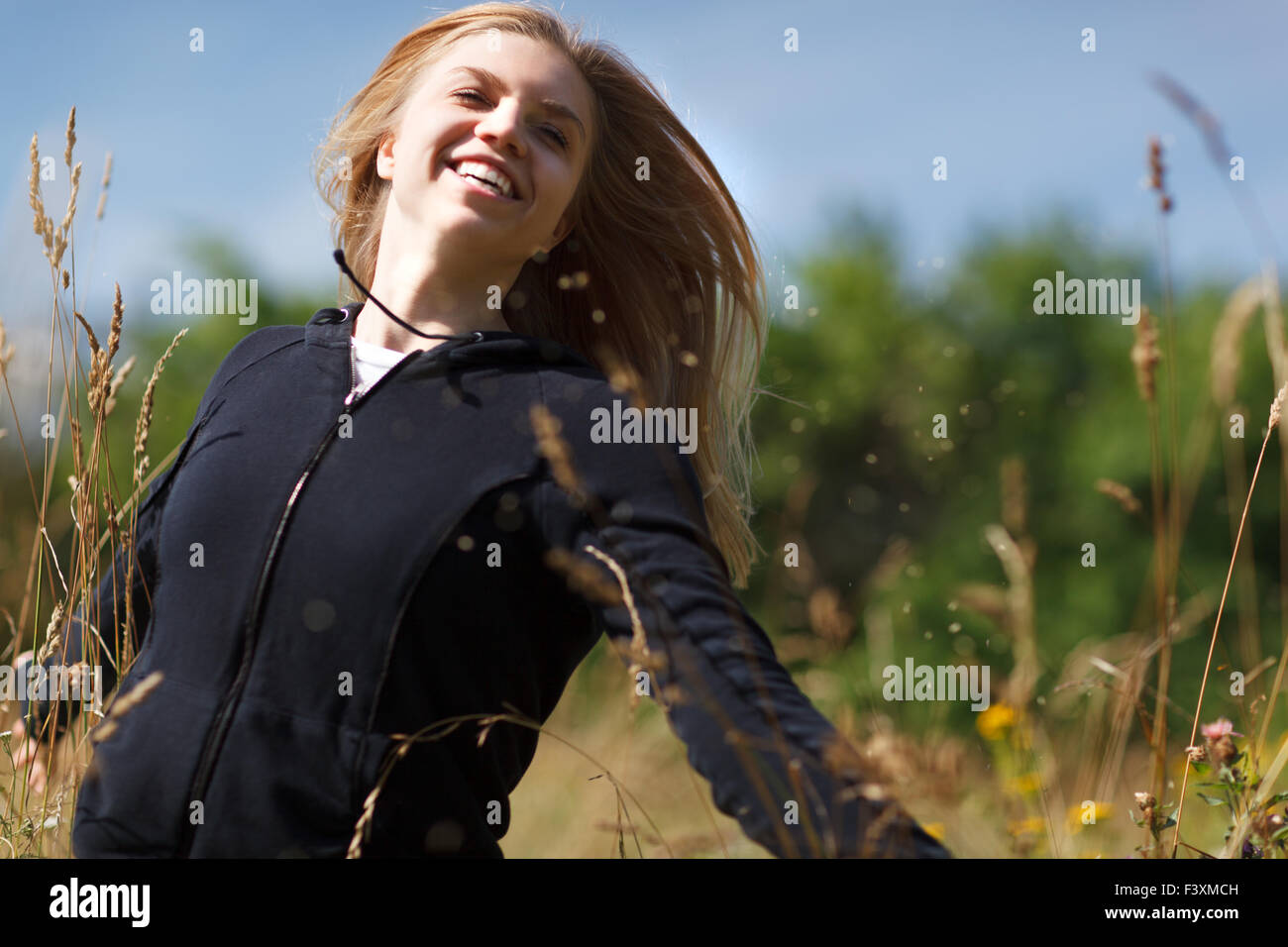 Young happy girl running in the field Stock Photo - Alamy