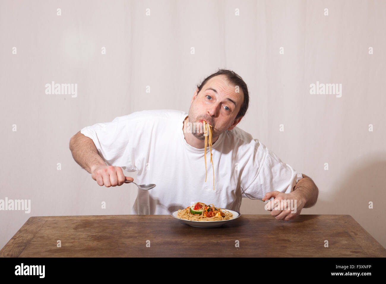 Happy man eating spaghetti hi-res stock photography and images - Alamy