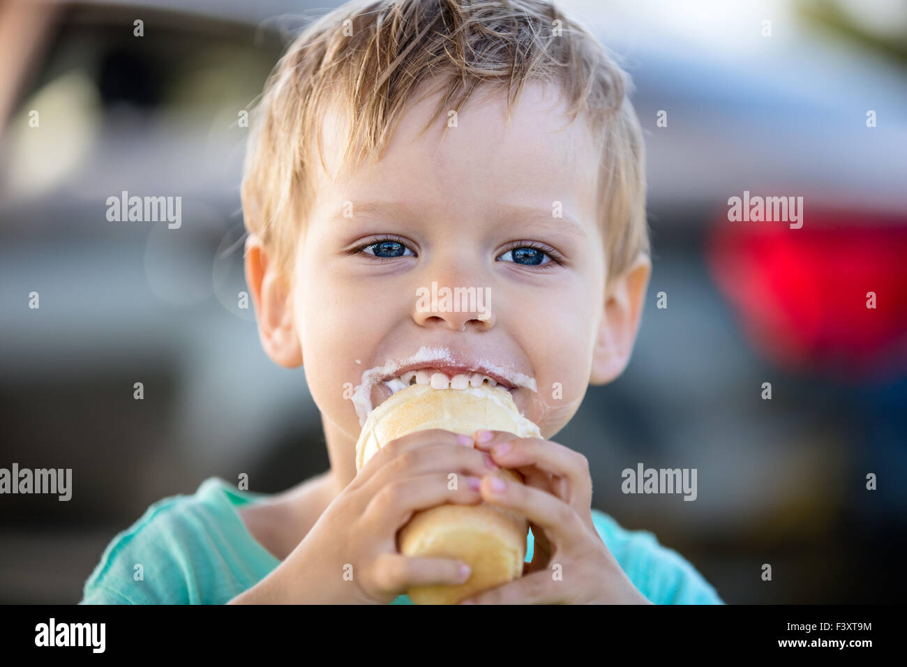Cute little boy eating ice-cream and smiling Stock Photo - Alamy