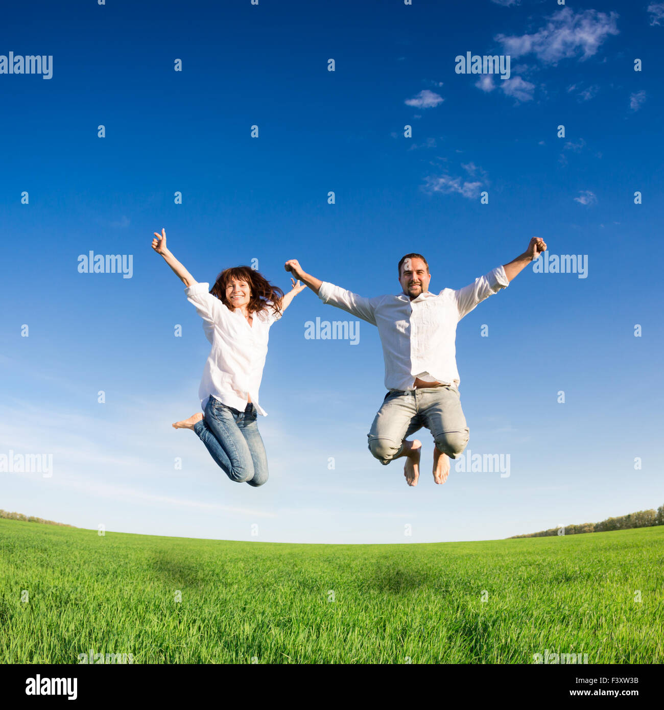 Happy couple jumping Stock Photo - Alamy