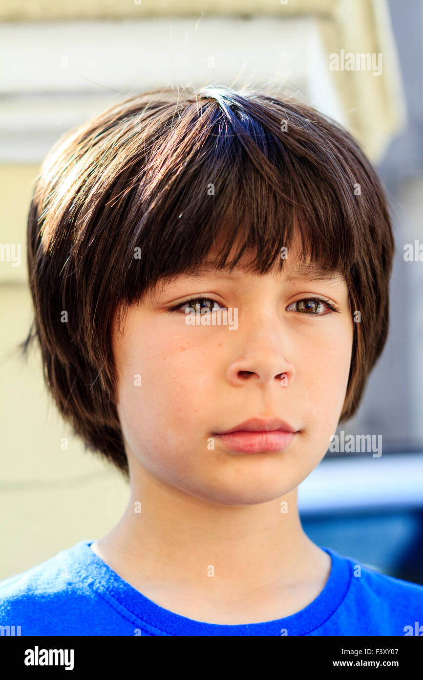 Brown haired Caucasian child, boy, 9-10 year old, standing outdoors ...