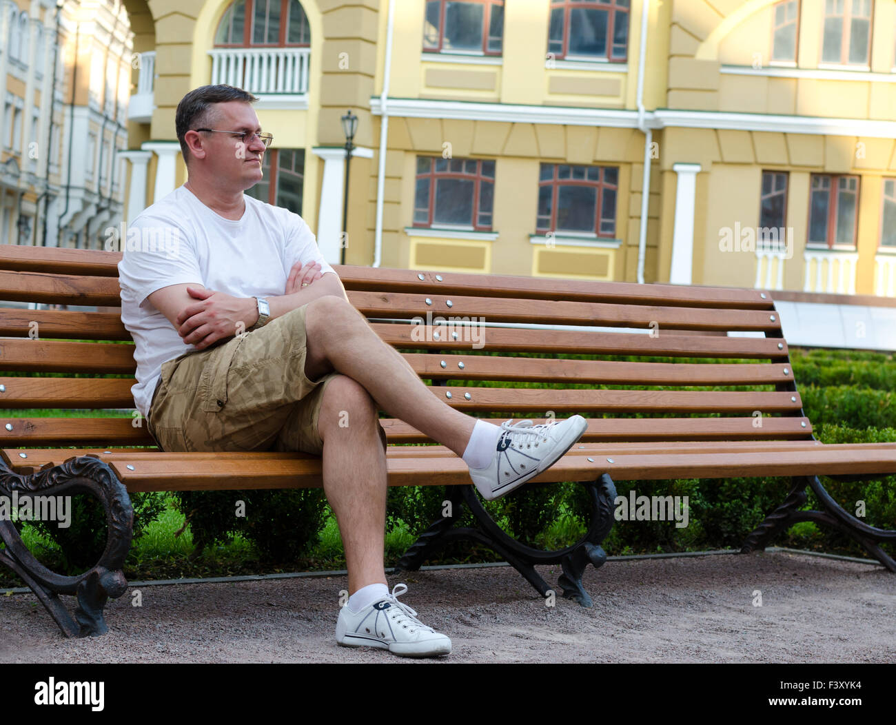 Man sitting waiting on an urban bench Stock Photo - Alamy