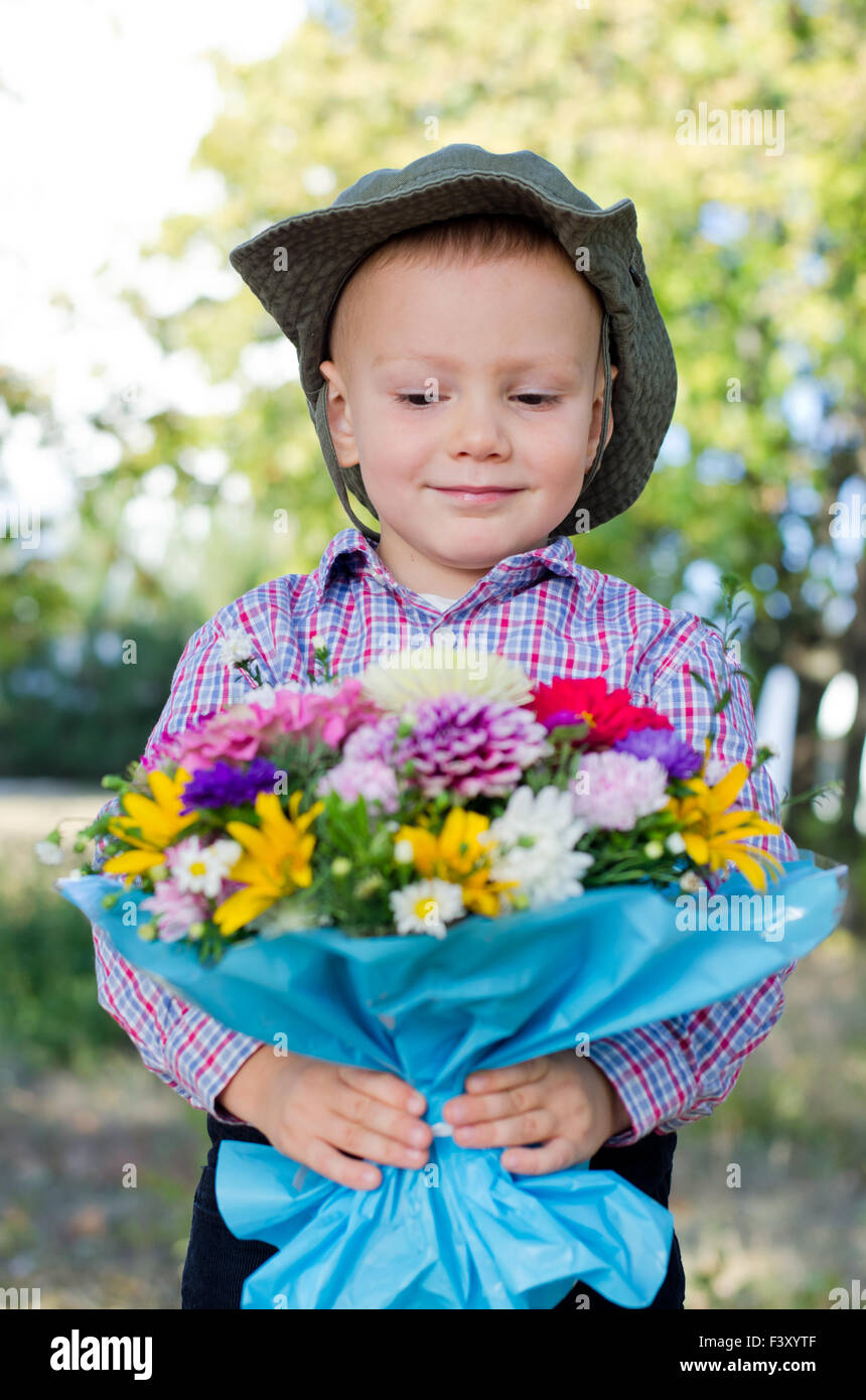 Smiling child presenting flowers Stock Photo - Alamy