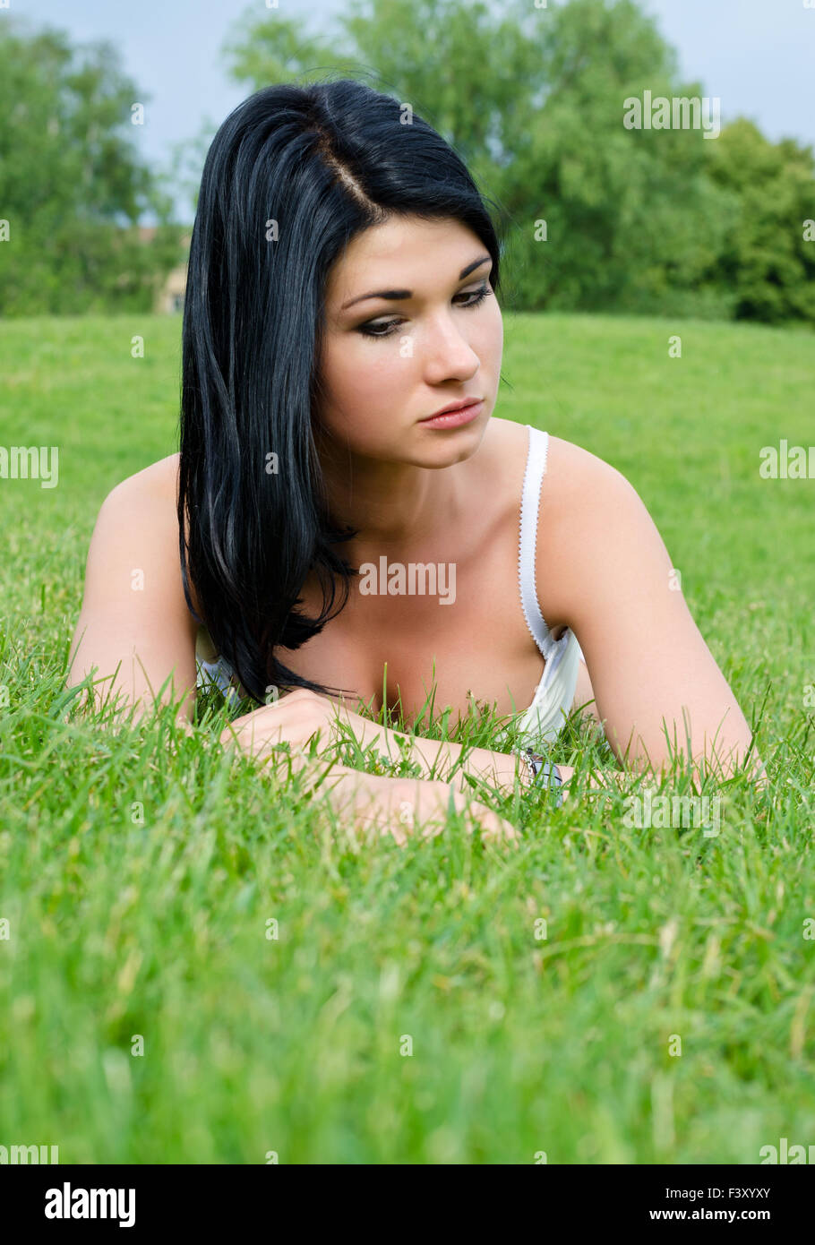 Beautiful pensive woman lying on grass Stock Photo - Alamy Beautiful pensive woman lying on grass Stock Photo - Alamy