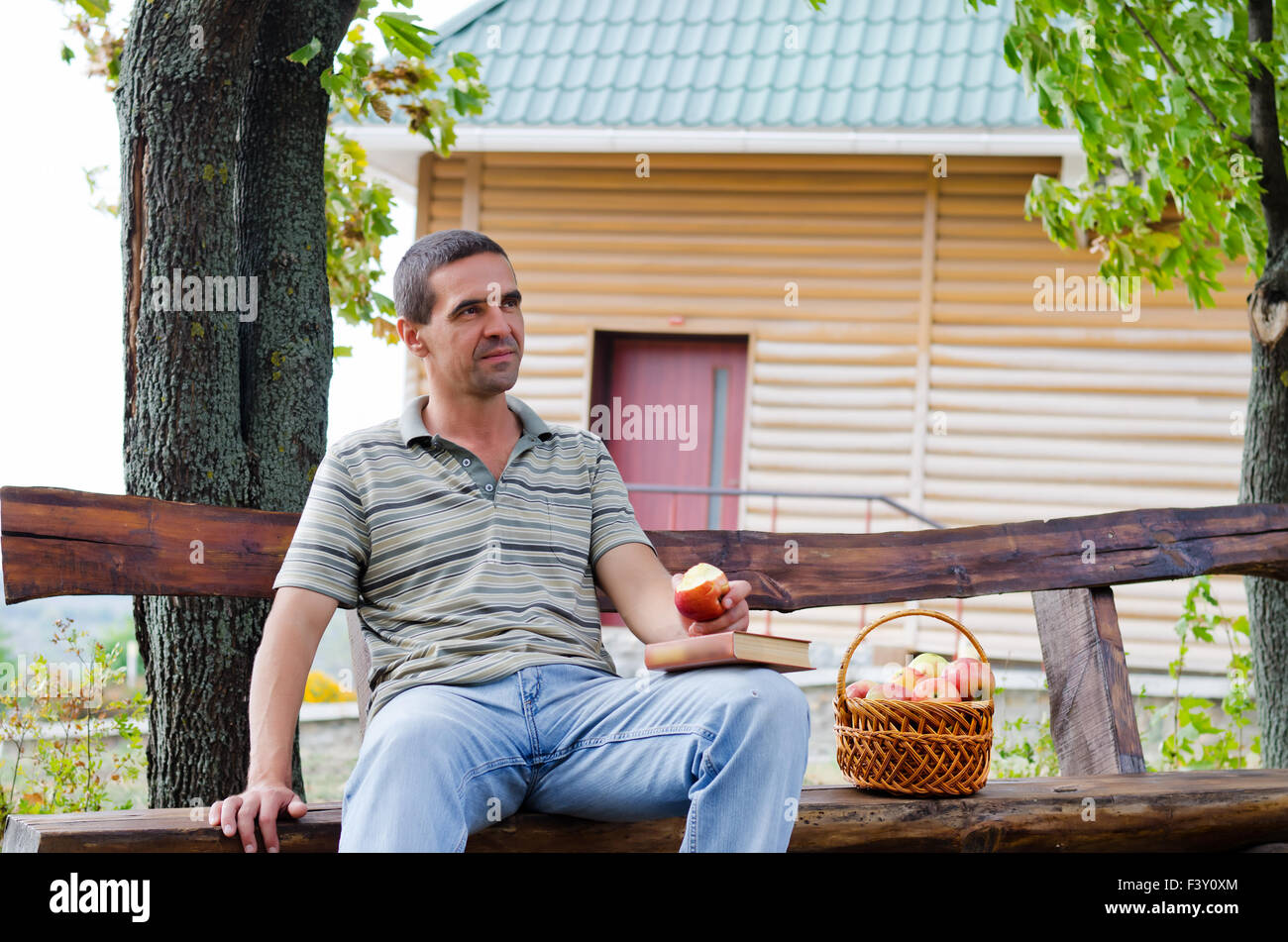 Thoughtful man eating an apple outdoors Stock Photo - Alamy