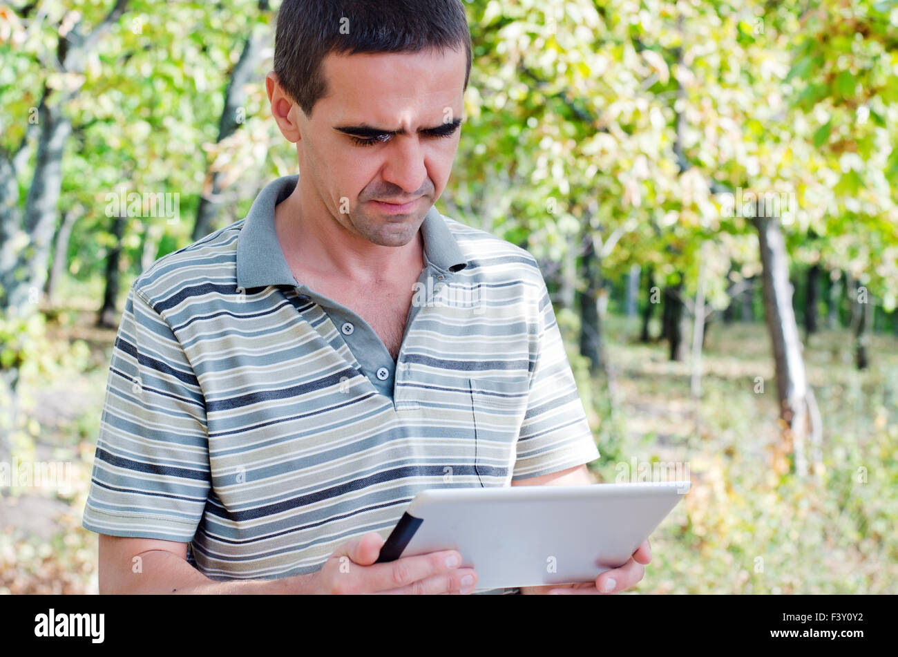 Man reading the screen on his tablet Stock Photo - Alamy