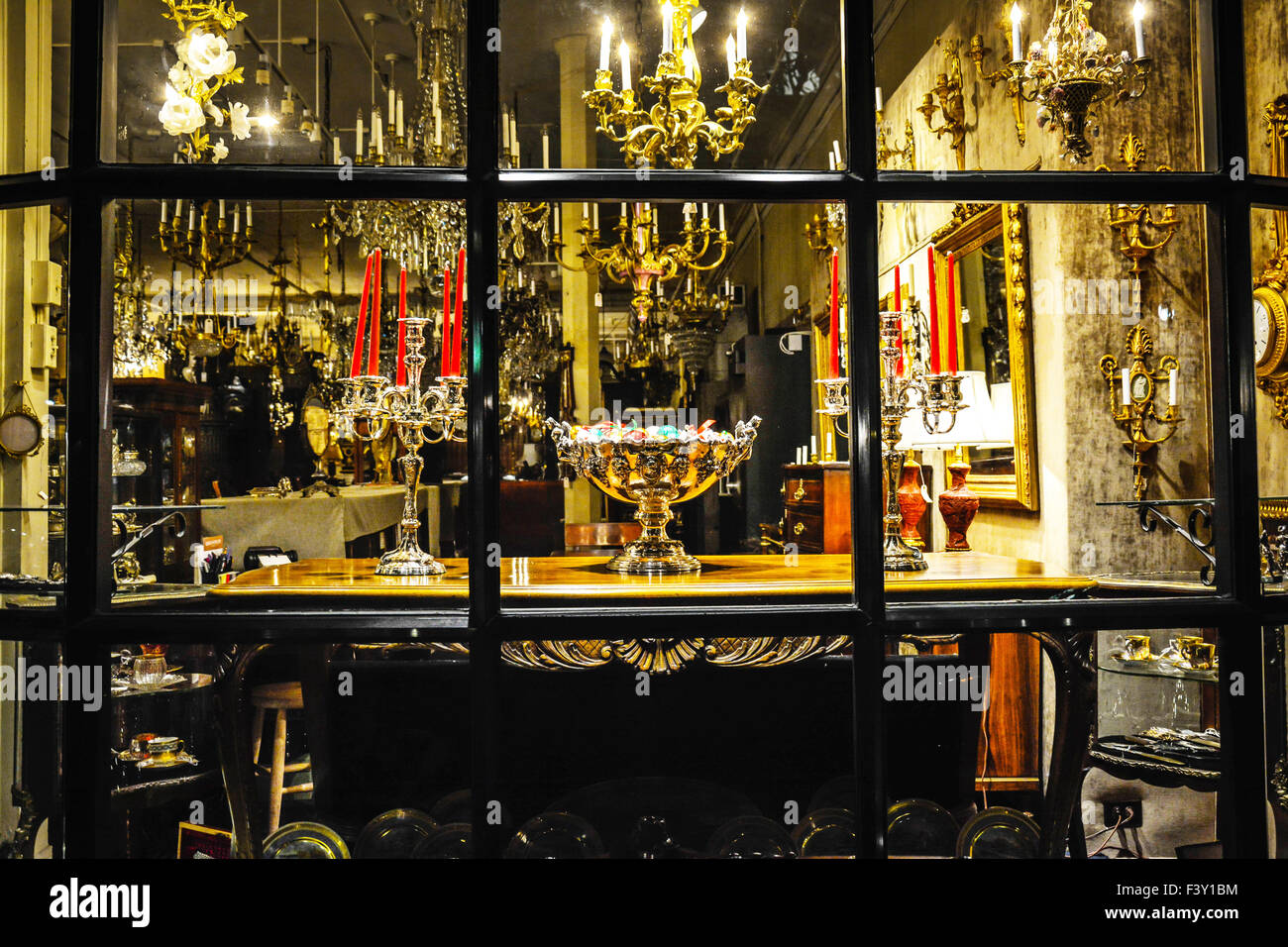 A mesmerizing night time Storefront window of antique chandeliers and ...