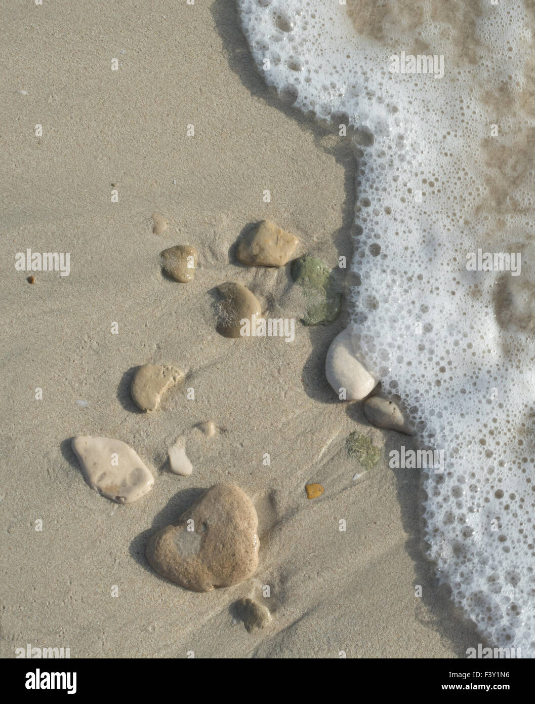 Stones on sand and motion blurry wave Stock Photo - Alamy